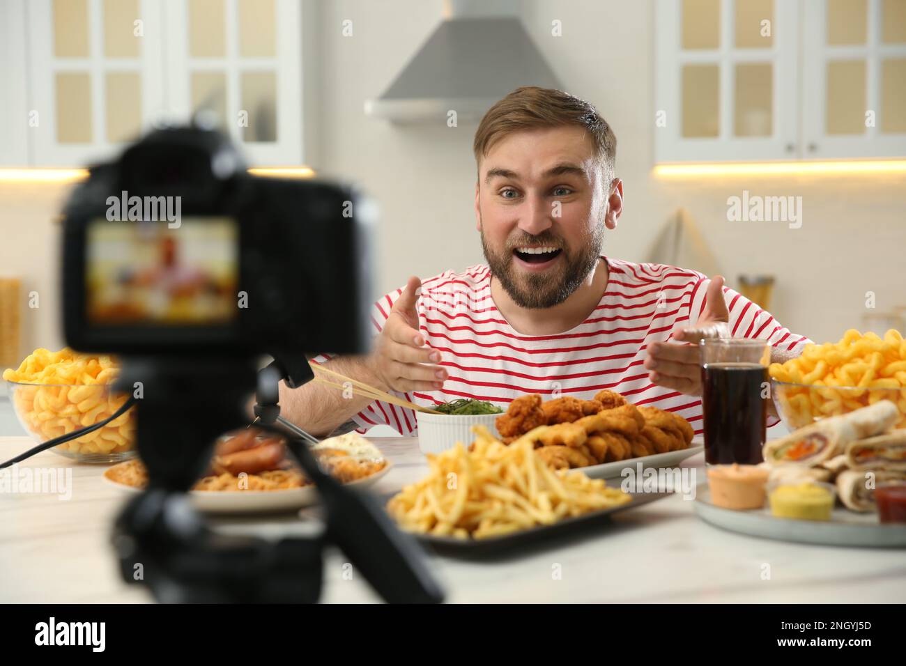 Food blogger recording eating show on camera in kitchen. Mukbang vlog ...