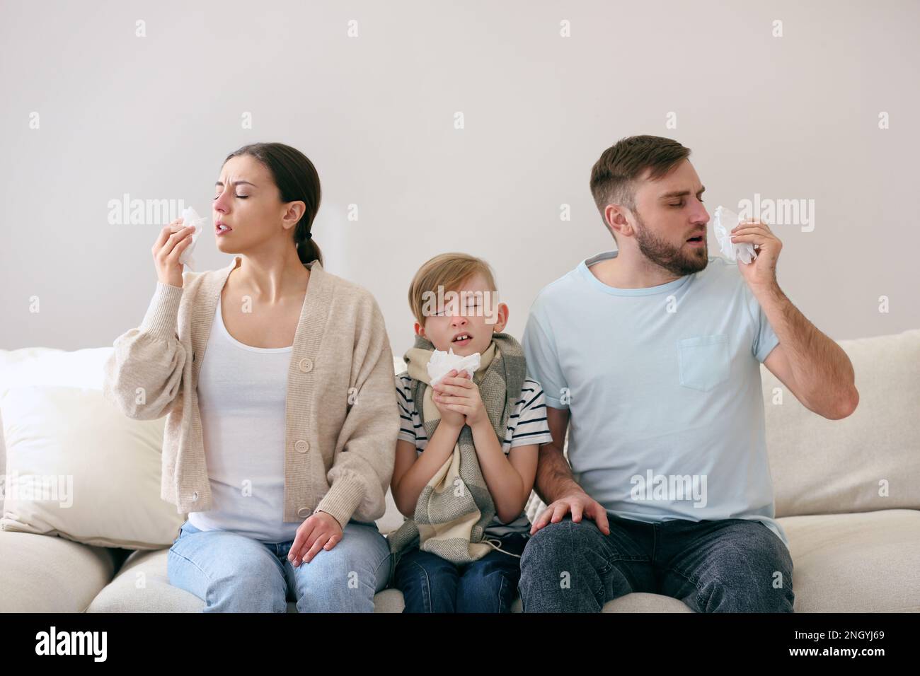 Family suffering from runny nose on sofa at home Stock Photo - Alamy