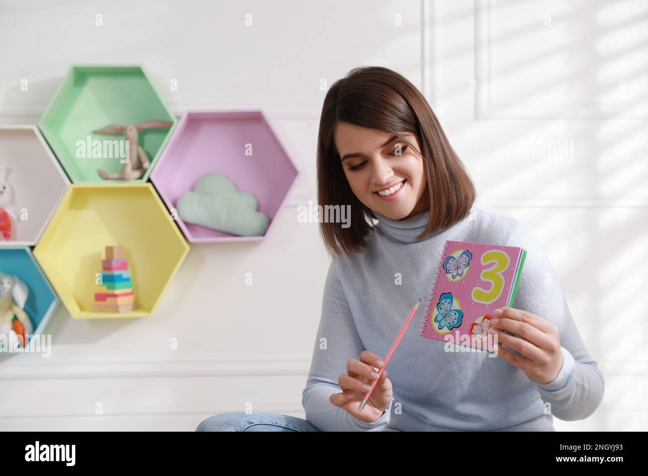 Happy female English teacher giving lesson indoors. Early childhood ...