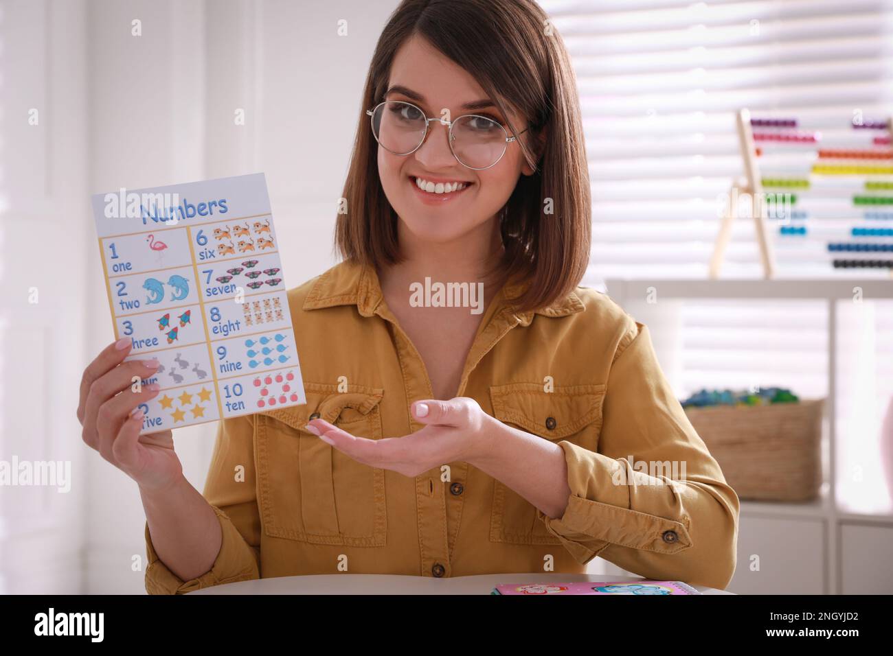 Happy female English teacher giving lesson indoors. Early childhood ...