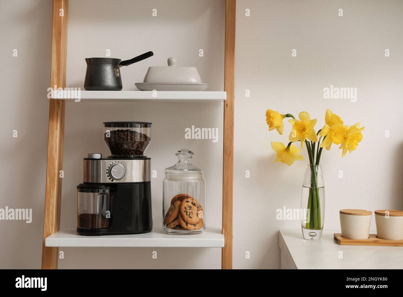 Modern coffee grinder on shelving unit in kitchen Stock Photo - Alamy