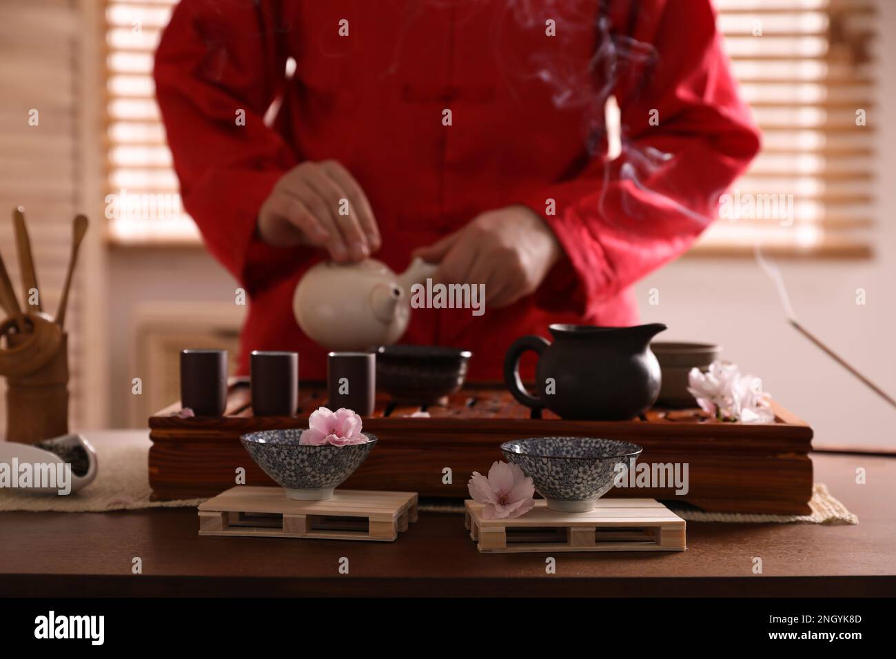 Master conducting traditional tea ceremony at table, focus on cups ...