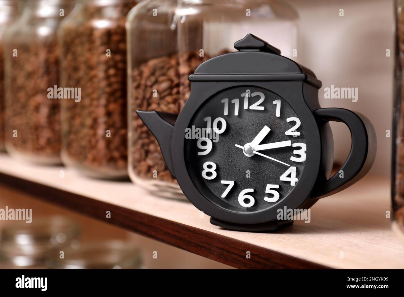 Teapot shaped clock on shelf with jars of coffee beans Stock Photo - Alamy