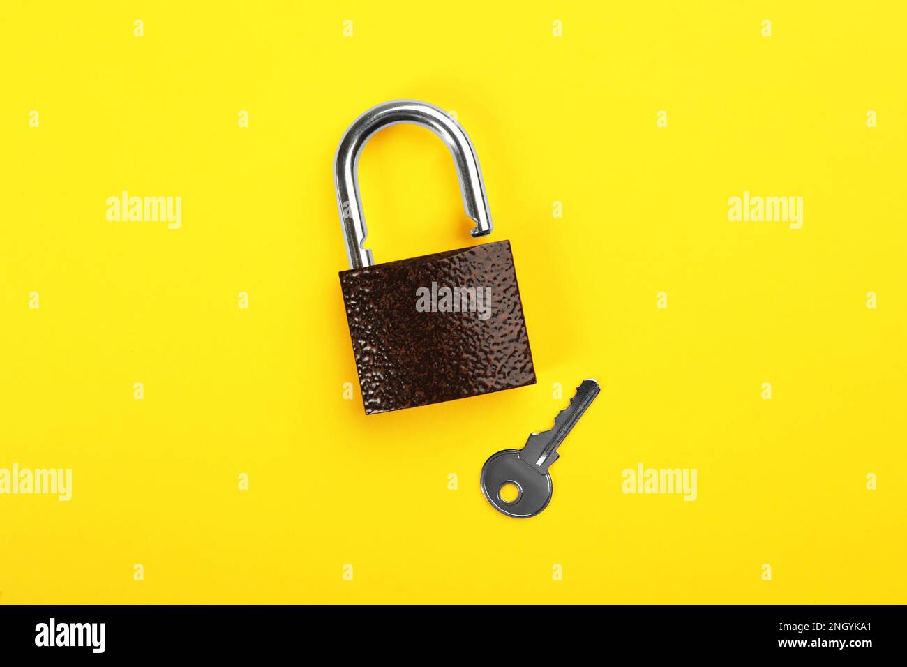 Modern padlock with key on yellow background, flat lay Stock Photo - Alamy