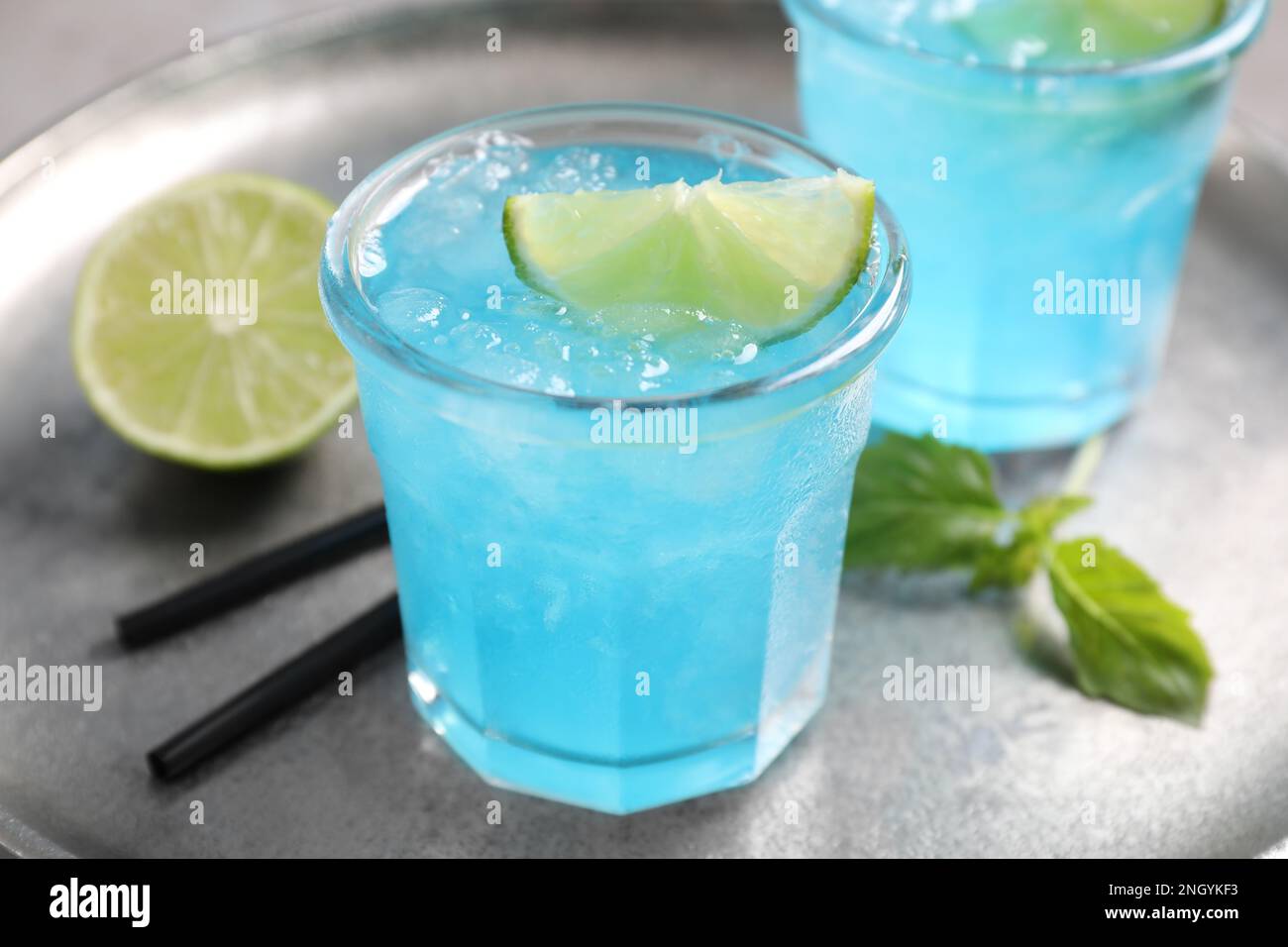 Tasty fresh light blue drink with lime on silver tray Stock Photo - Alamy