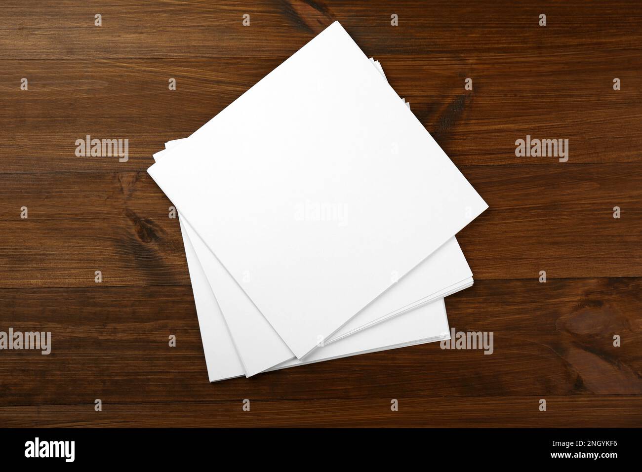 Stack of blank paper sheets on wooden table. Brochure design Stock ...