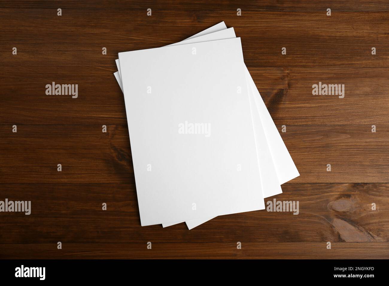 Stack of blank paper sheets on wooden table, top view. Brochure design ...