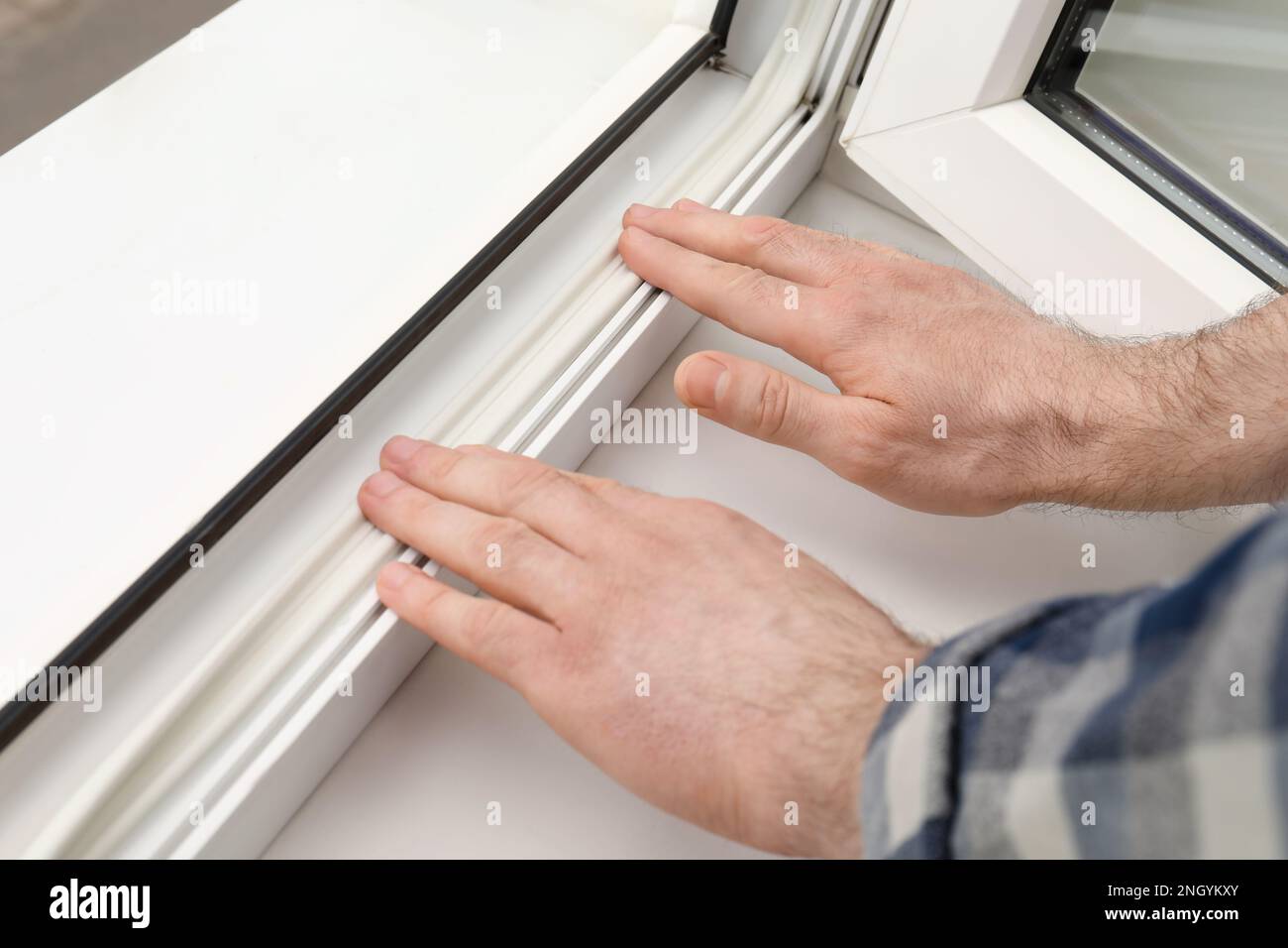 Worker putting rubber draught strip onto window indoors, closeup Stock ...