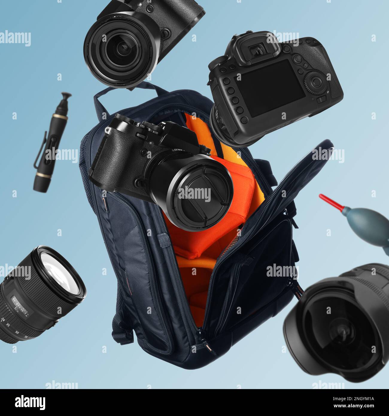 Different professional photography equipment falling on light blue ...
