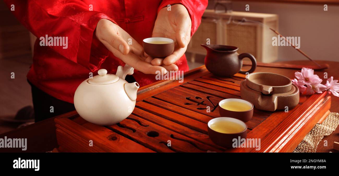 Guest holding cup of freshly brewed tea during traditional ceremony at ...