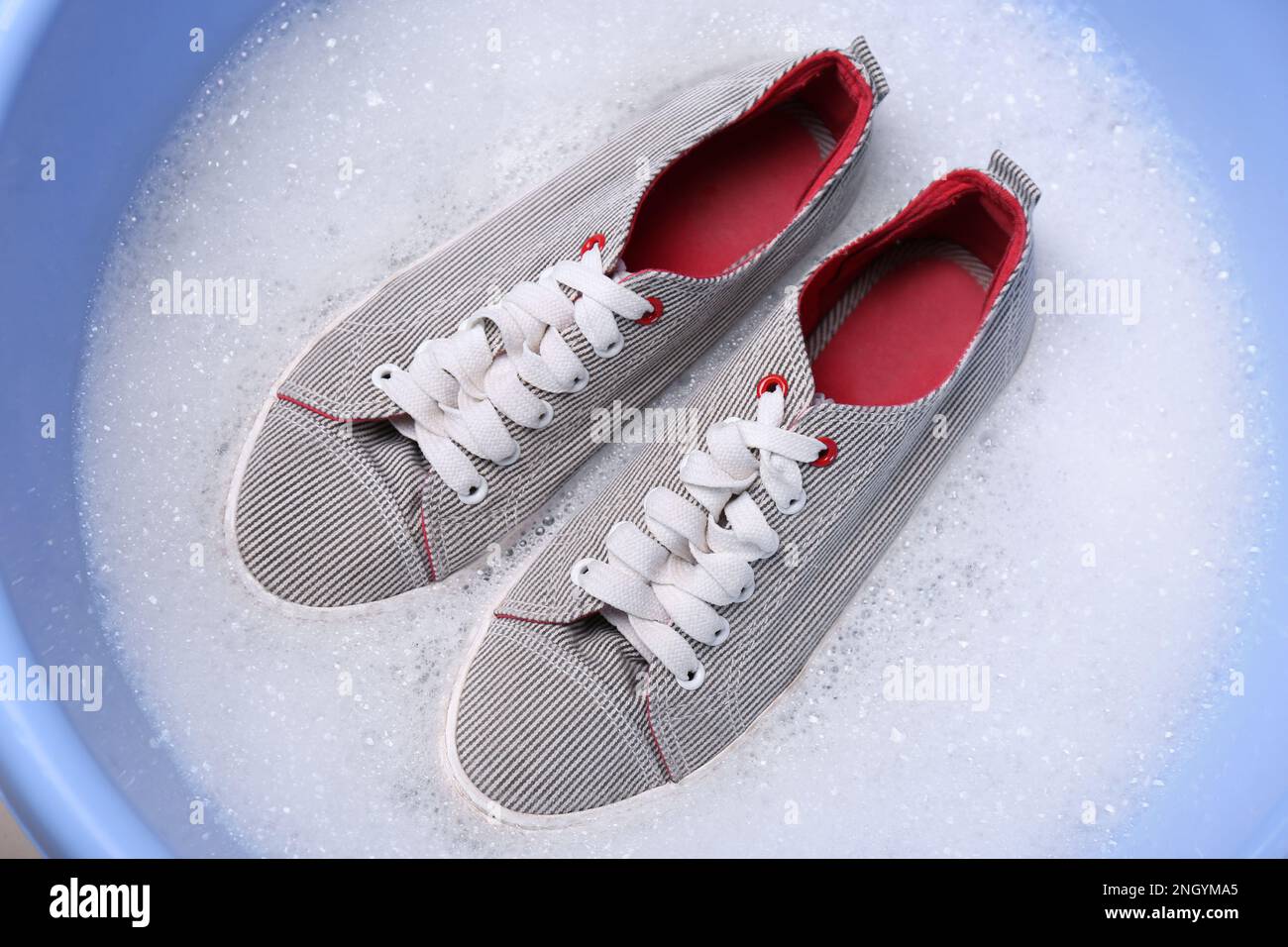 Washing pair of sport shoes in plastic basin Stock Photo - Alamy
