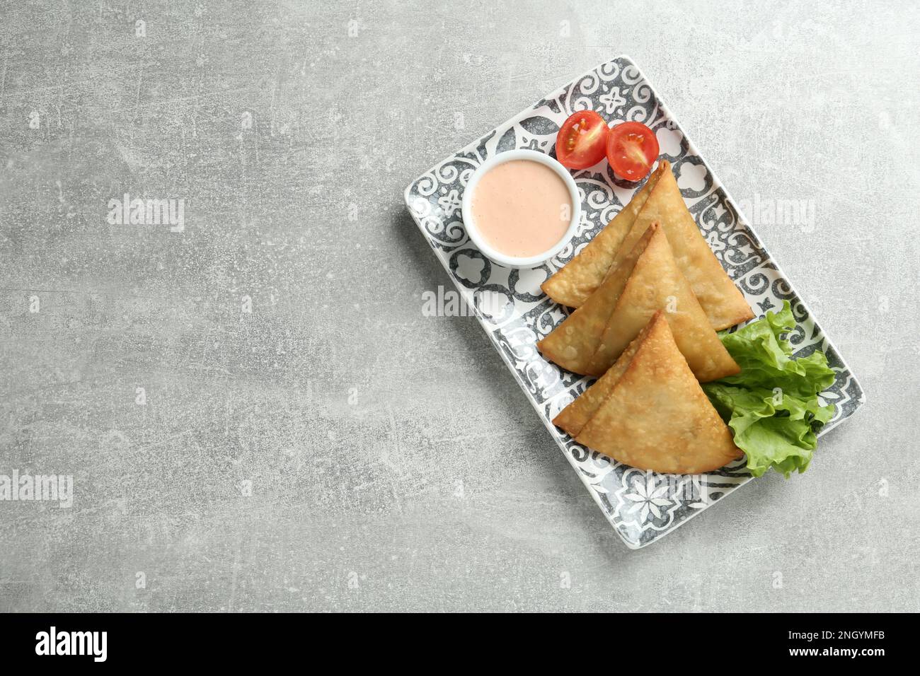 Fresh delicious crispy samosas served on grey table, top view. Space ...