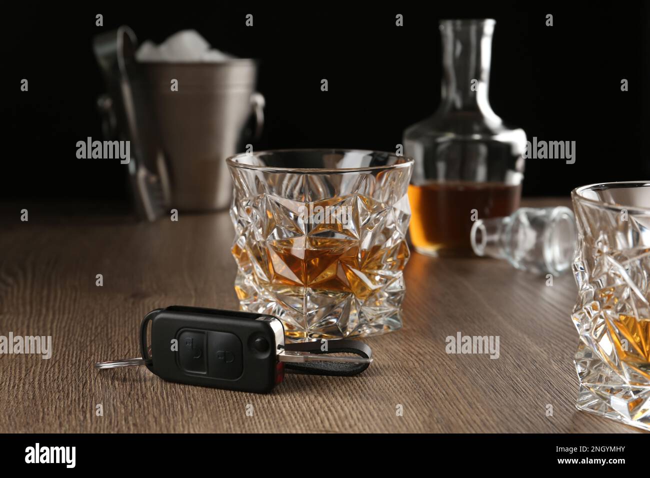 Glass of alcohol and car key on wooden table. Drunk driving concept ...
