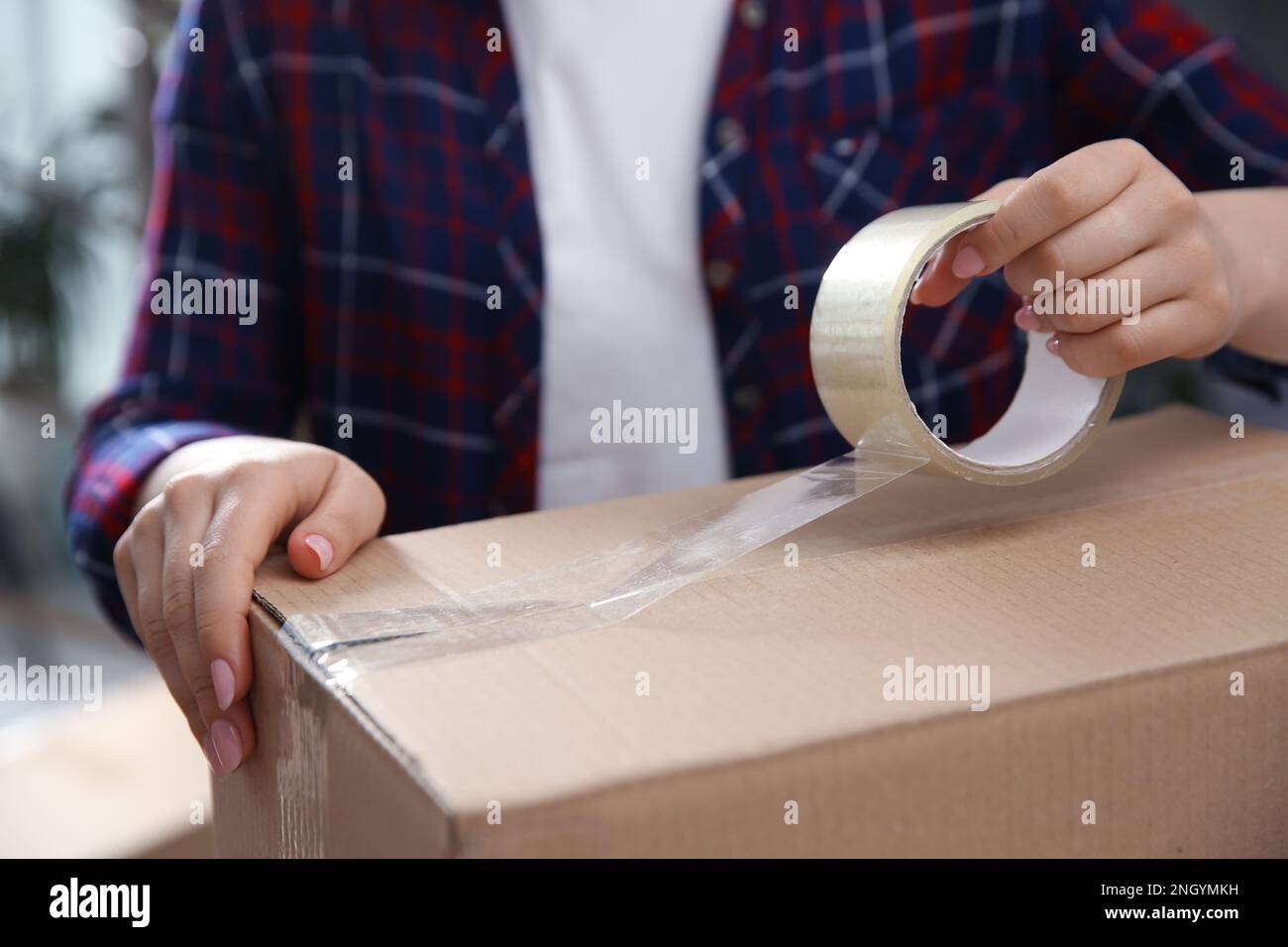 Woman taping cardboard box indoors, closeup. Moving day Stock Photo - Alamy