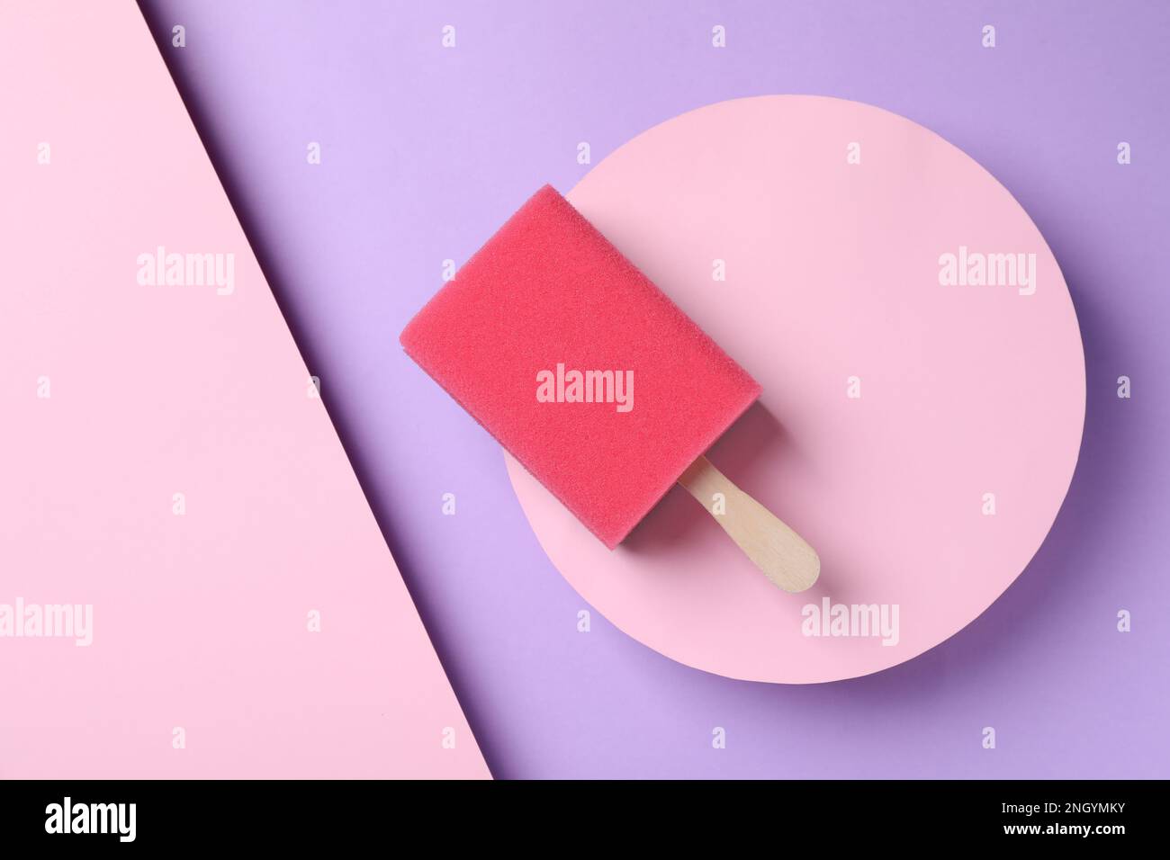 Sponge with wooden stick as ice cream on color background, top view ...