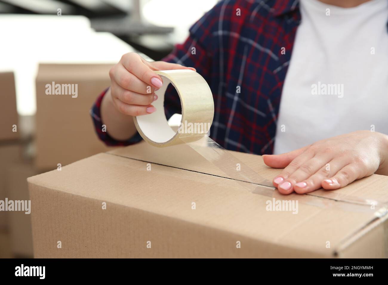 Woman taping cardboard box indoors, closeup. Moving day Stock Photo - Alamy