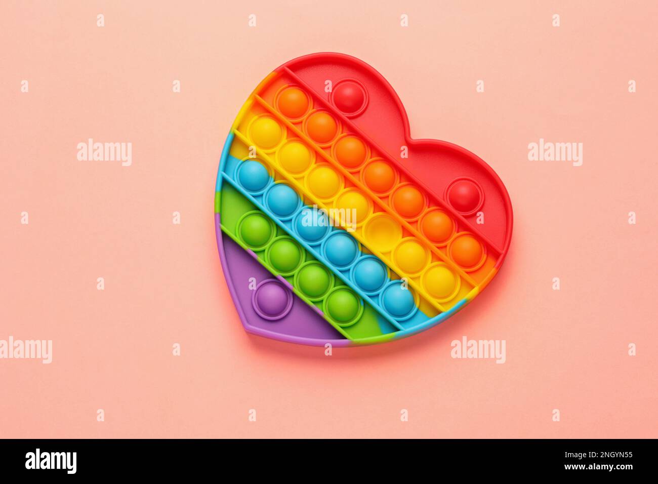 Heart shaped rainbow pop it fidget toy on pink background, top view ...