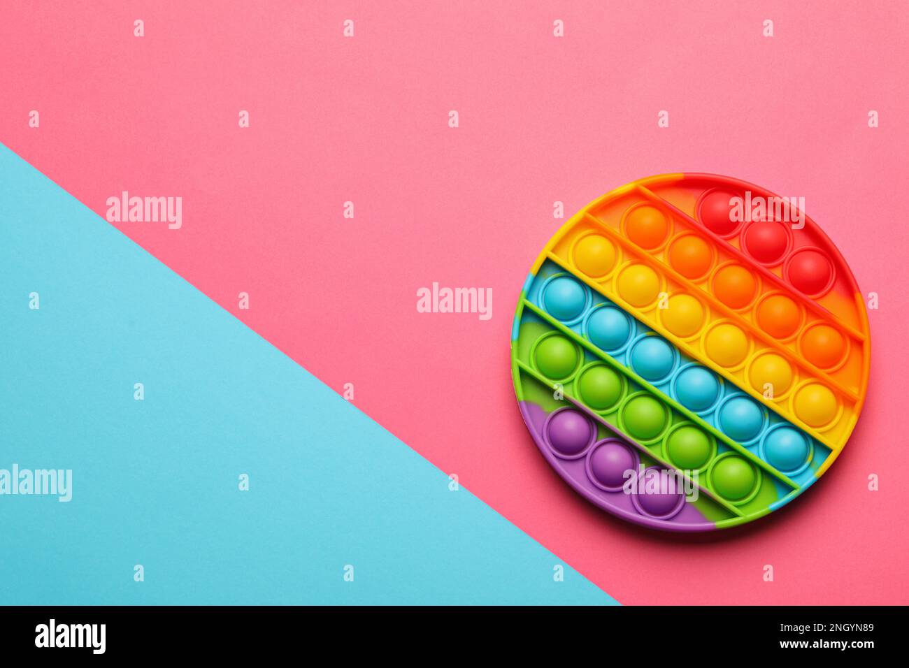 Rainbow pop it fidget toy on color background, top view. Space for text ...