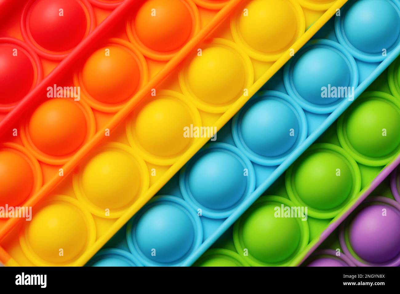 Rainbow pop it fidget toy as background, closeup Stock Photo - Alamy