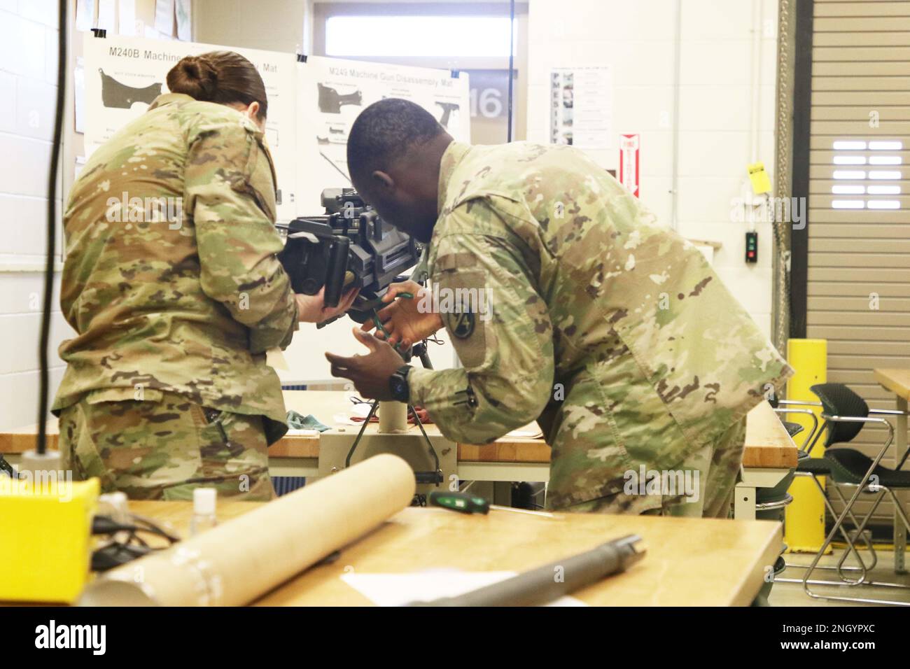 Sgt. 1st Class Jerry Fumba assist Spc. Emma Burbridge with reassembling ...