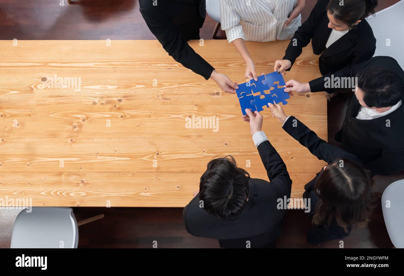 Top view businesspeople and colleagues in formal wear putting jigsaw ...