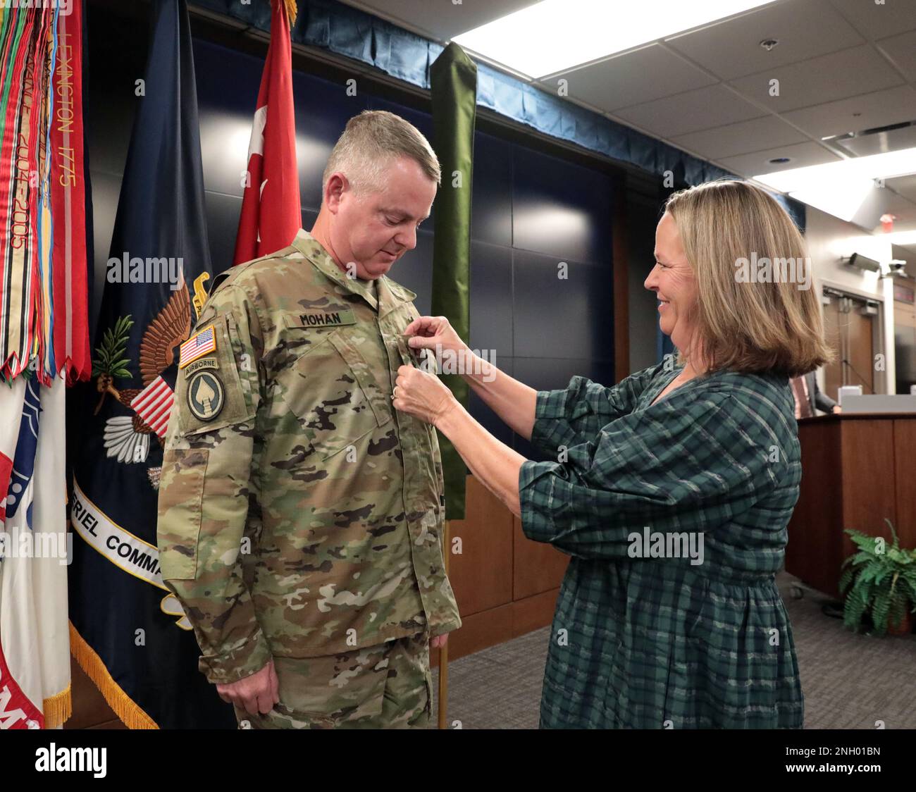 Cindy Mohan places the three stars insignia onto her husband's uniform ...