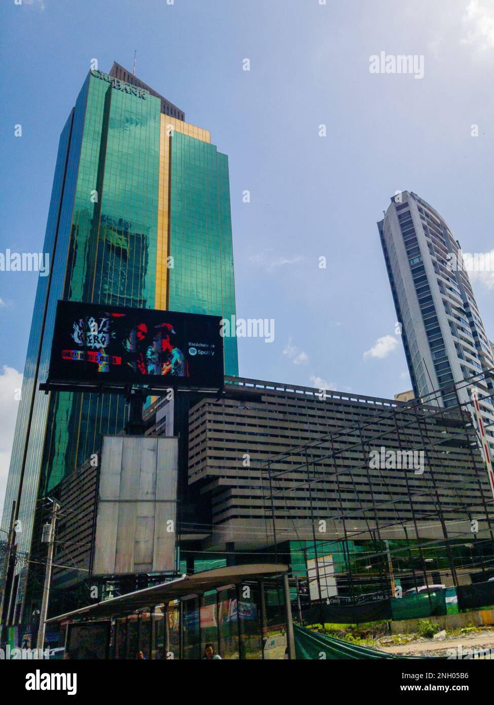 skyscraper with green glass windows, below a screen with advertising ...