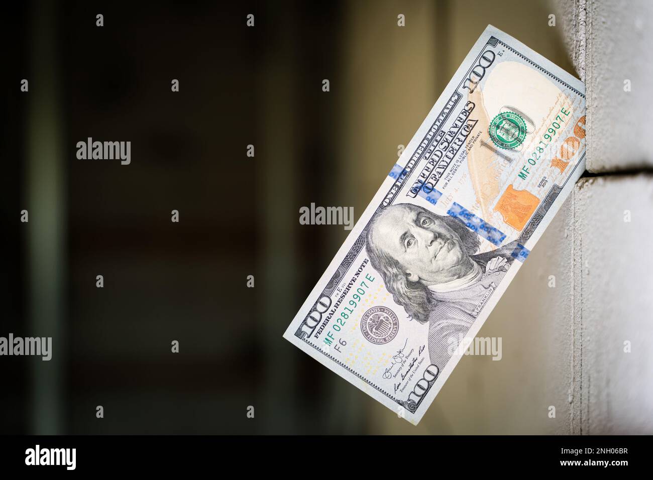 Hundred dollar bill at a construction site close-up on a blurred dark ...