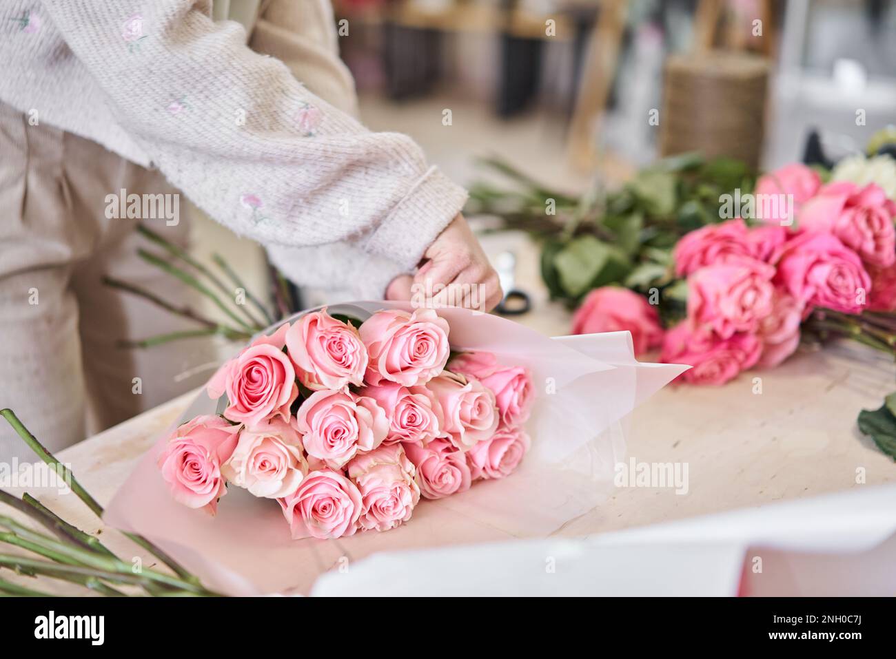 Florist at work. Summer bouquet of roses. Learning flower arranging ...