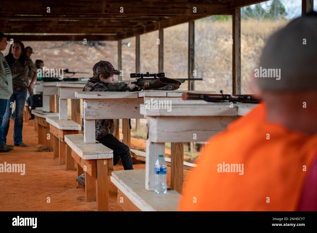 A youth hunting event participant calibrates their rifle sights at ...