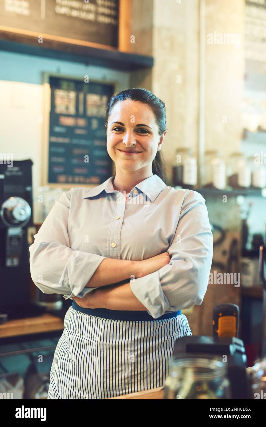 I couldnt be more proud of my cafe. Portrait of a young woman working ...