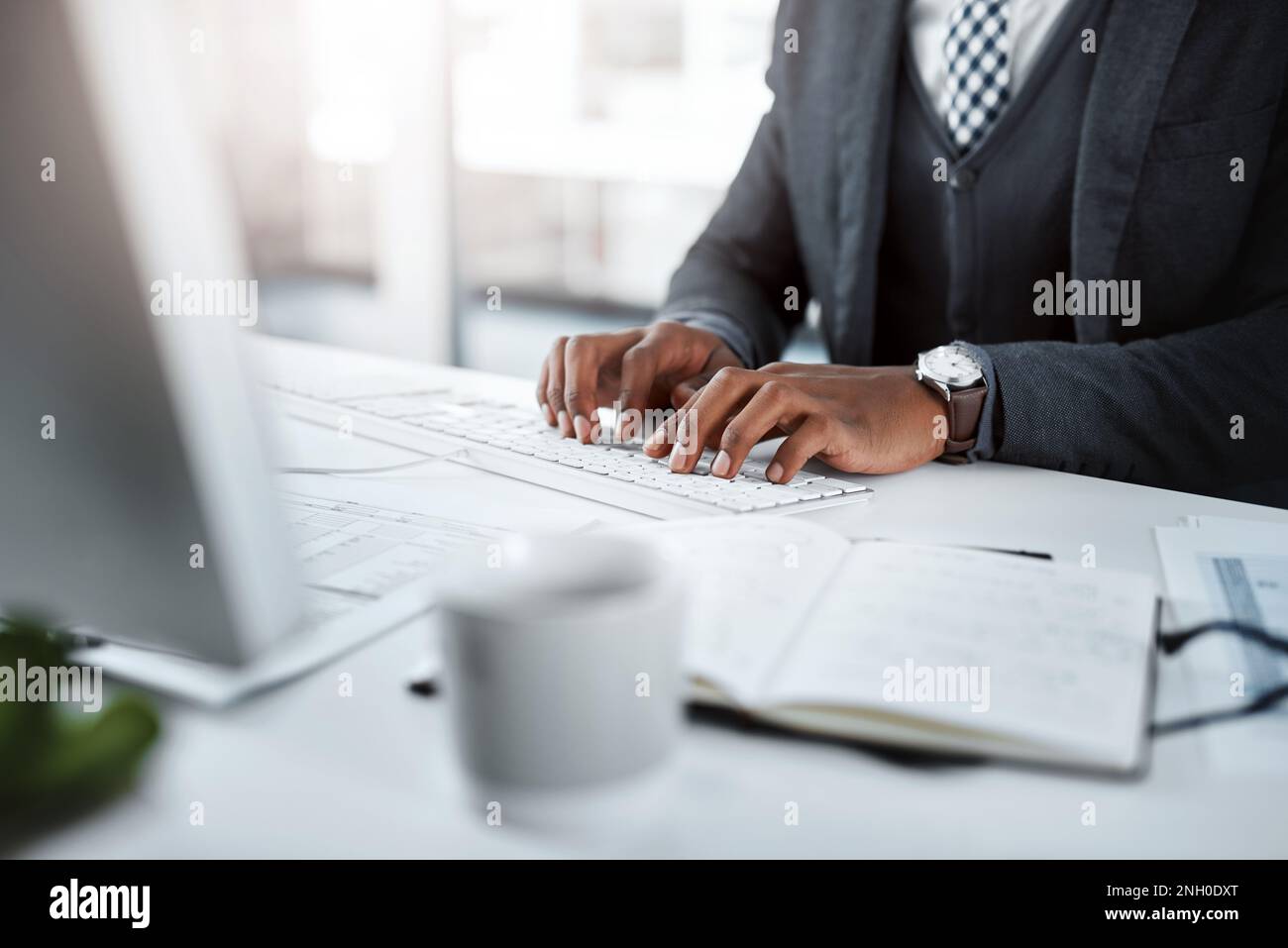Hardworking hands. a businessman using a computer at his desk in a ...