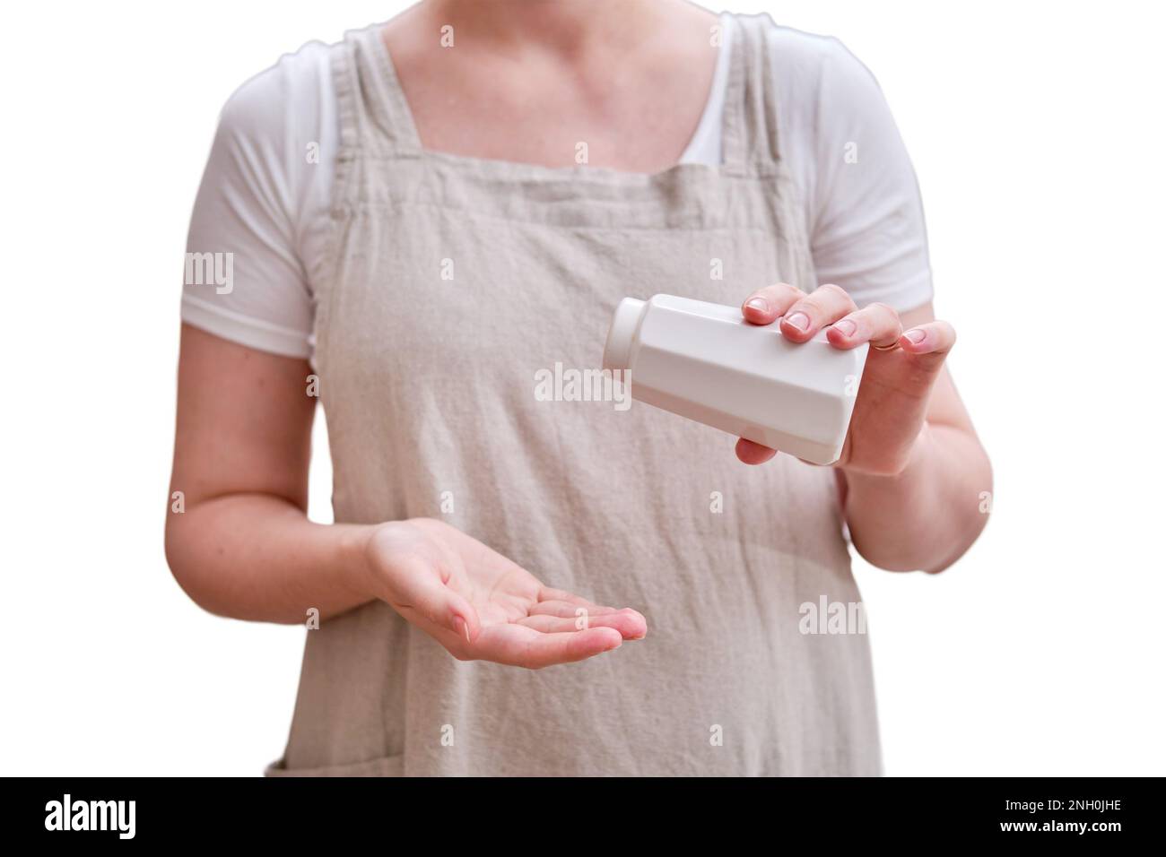 A white salt shaker in the hands of a woman in the kitchen, isolated on ...