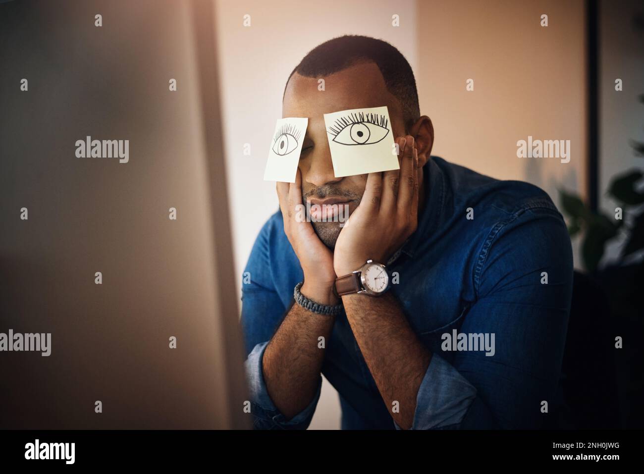 I promise Im awake. a tired young businessman working late in an office ...