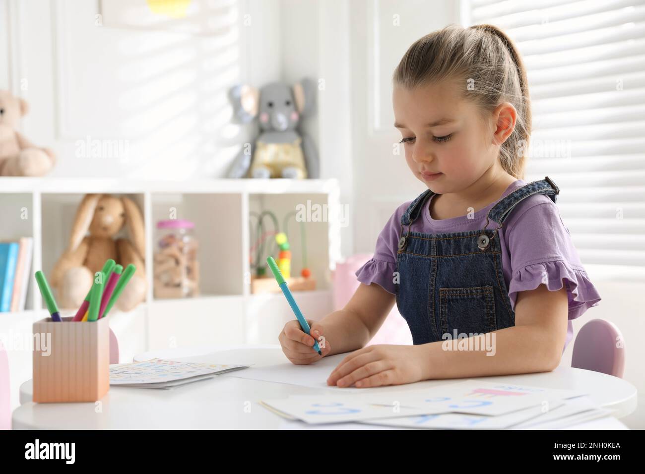 Little girl writing in classroom at English lesson Stock Photo - Alamy