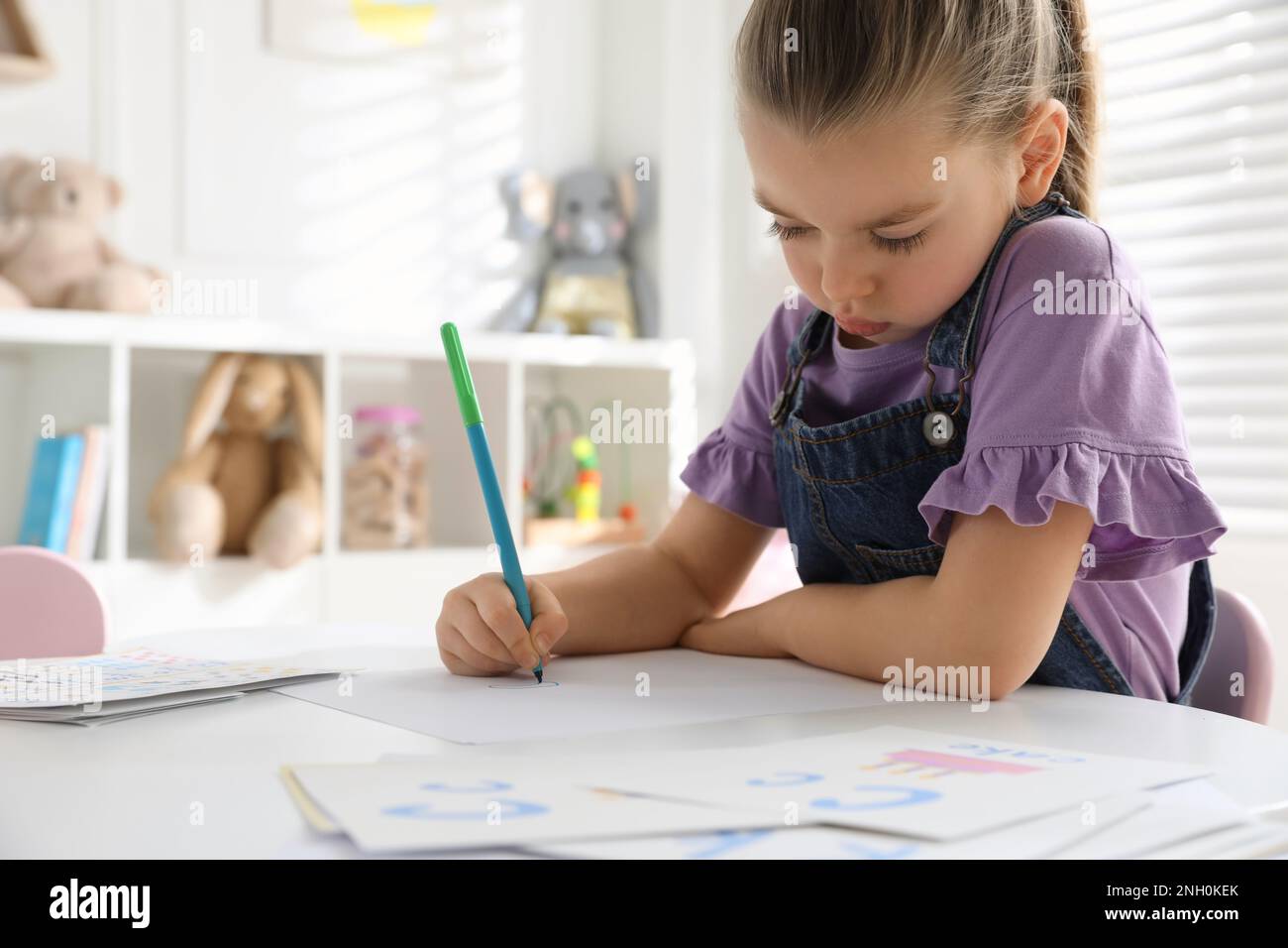 Little girl writing in classroom at English lesson Stock Photo - Alamy