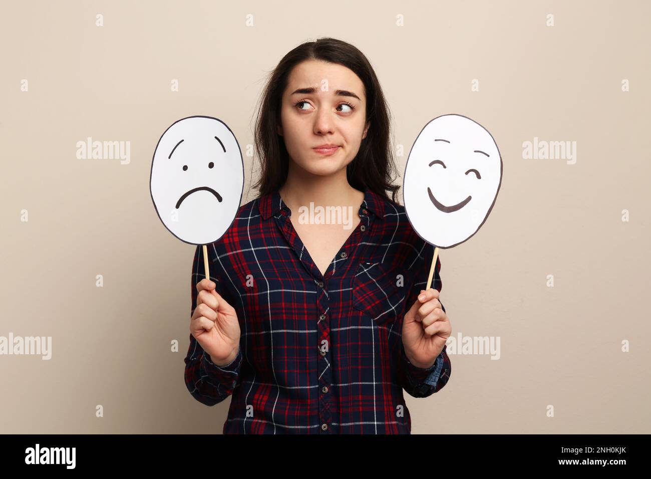 Woman with sad and happy paper faces on beige background Stock Photo ...
