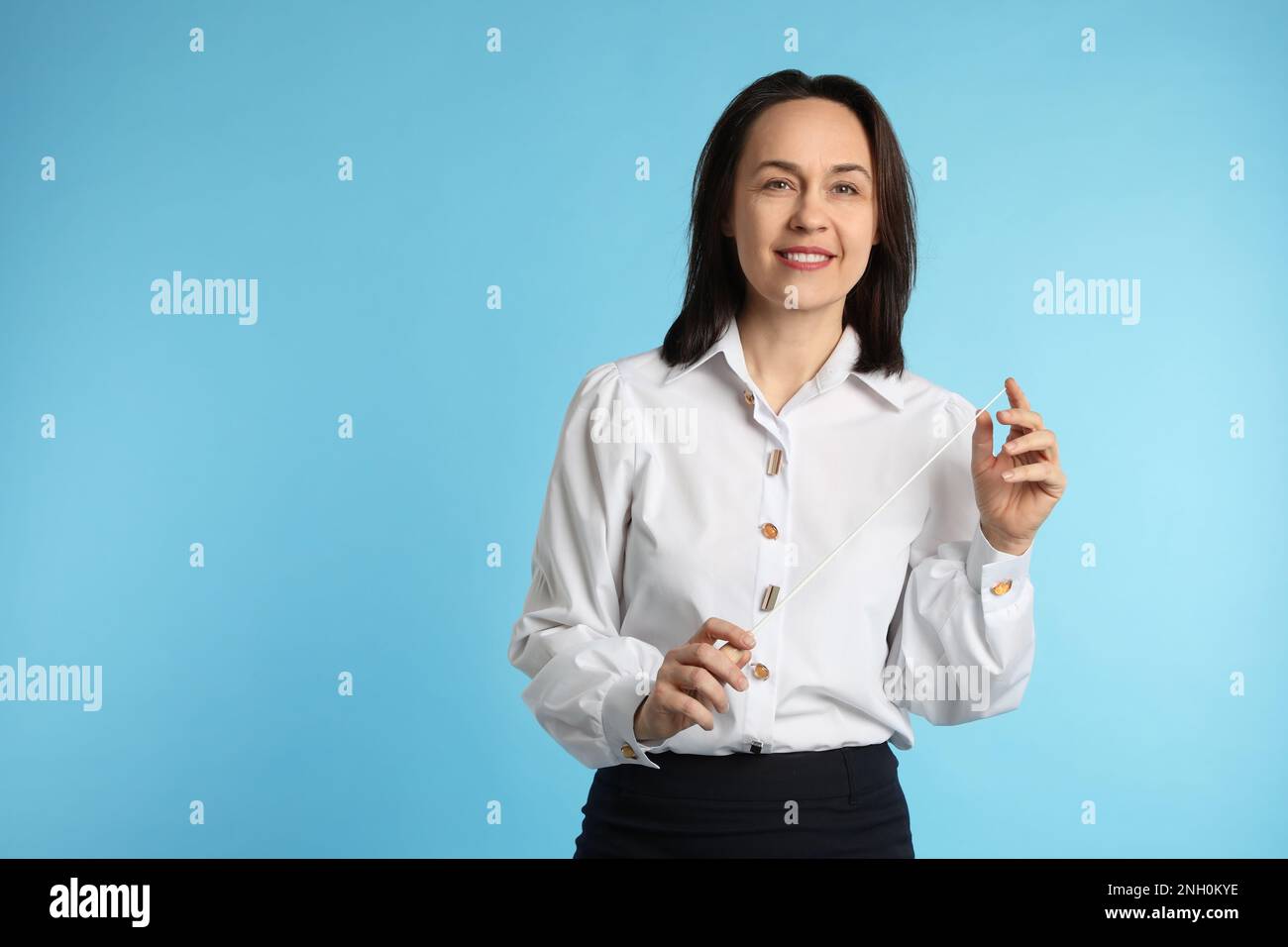 Music teacher with baton on turquoise background Stock Photo - Alamy