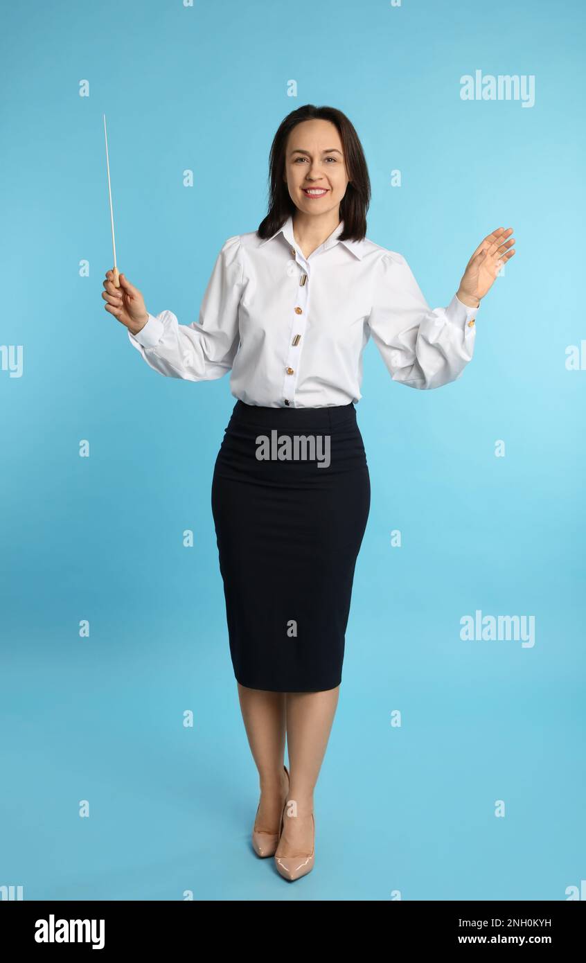 Music teacher with baton on turquoise background Stock Photo - Alamy