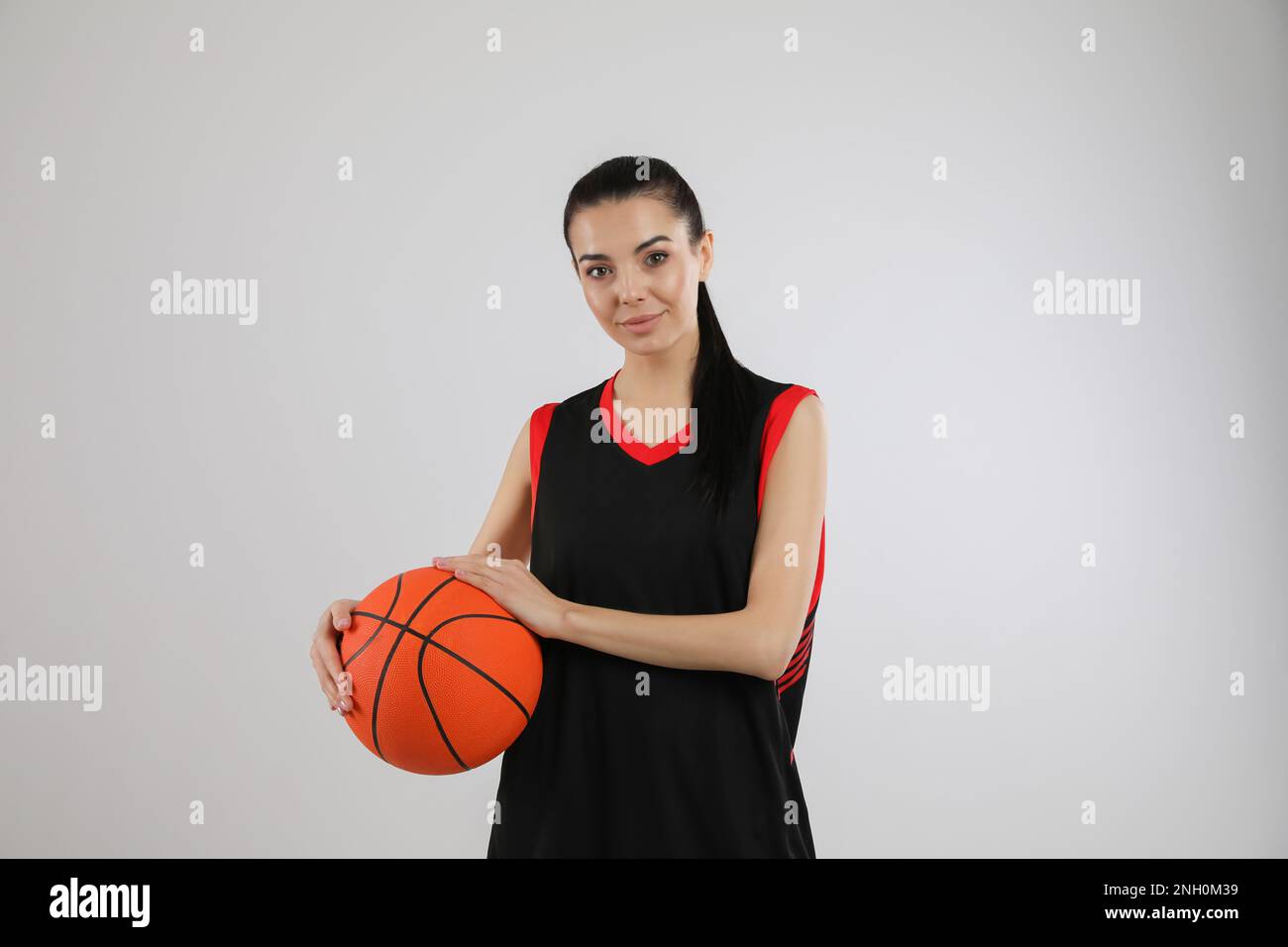 Basketball player with ball on grey background Stock Photo - Alamy