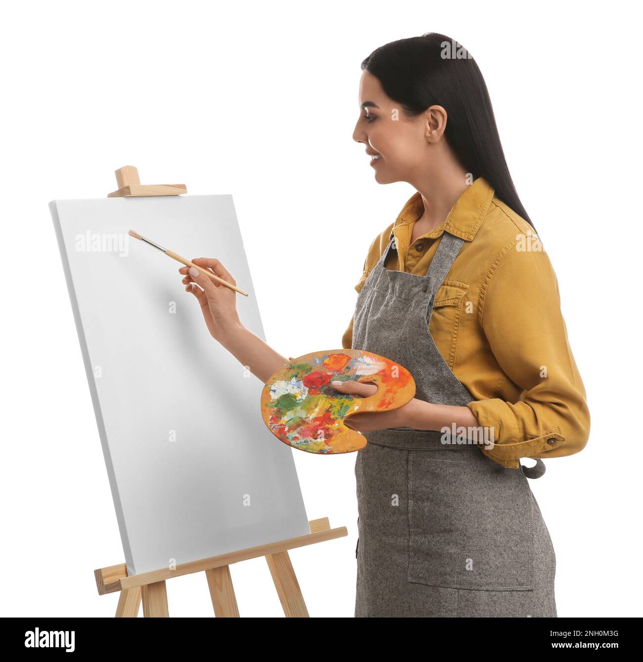 Young woman drawing on easel against white background Stock Photo - Alamy