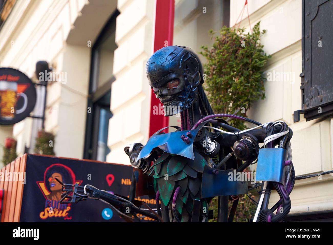 a statue of a metal skeleton of a robot at the entrance to the cafe ...