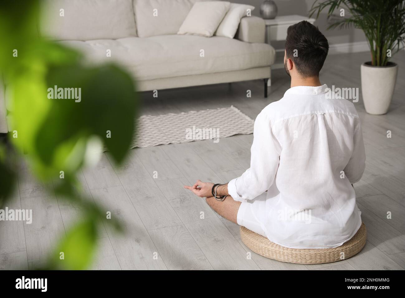 Man sitting yoga indoors cushion hi-res stock photography and images ...