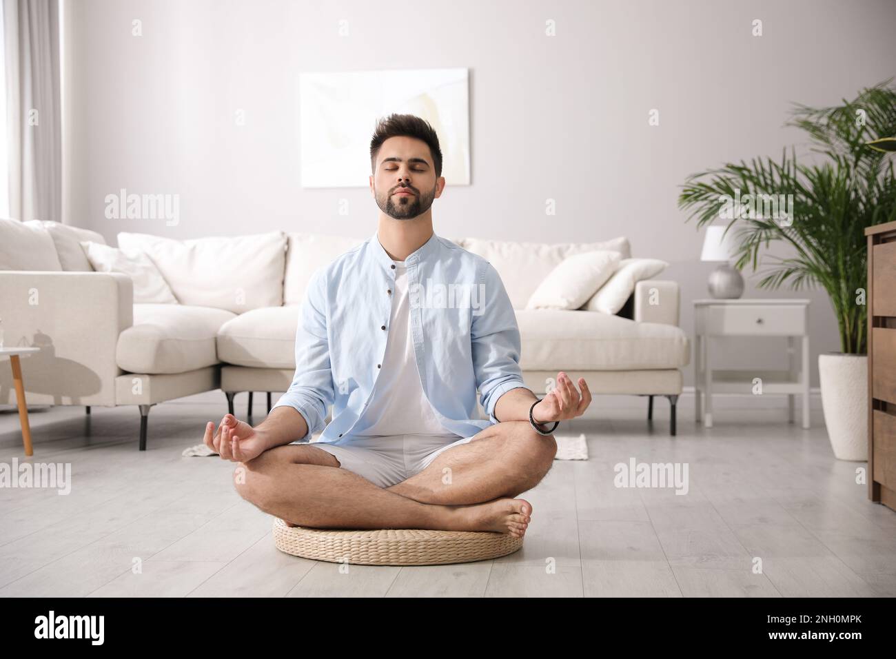 Man sitting yoga indoors cushion hi-res stock photography and images ...