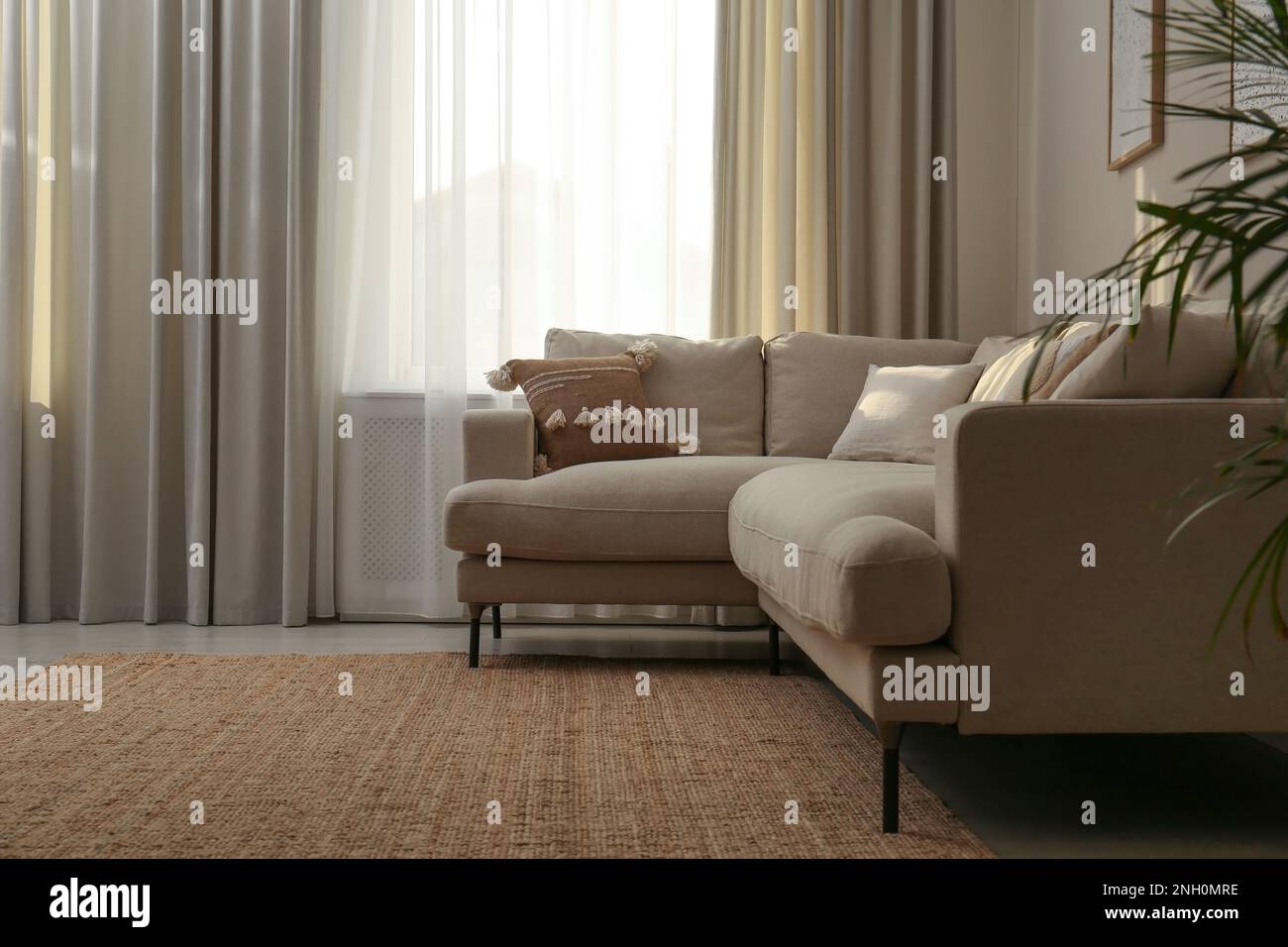 Modern comfortable sofa near window in stylish living room. Interior ...