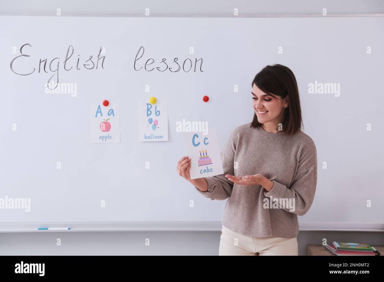 Happy female English teacher giving lesson indoors. Early childhood ...
