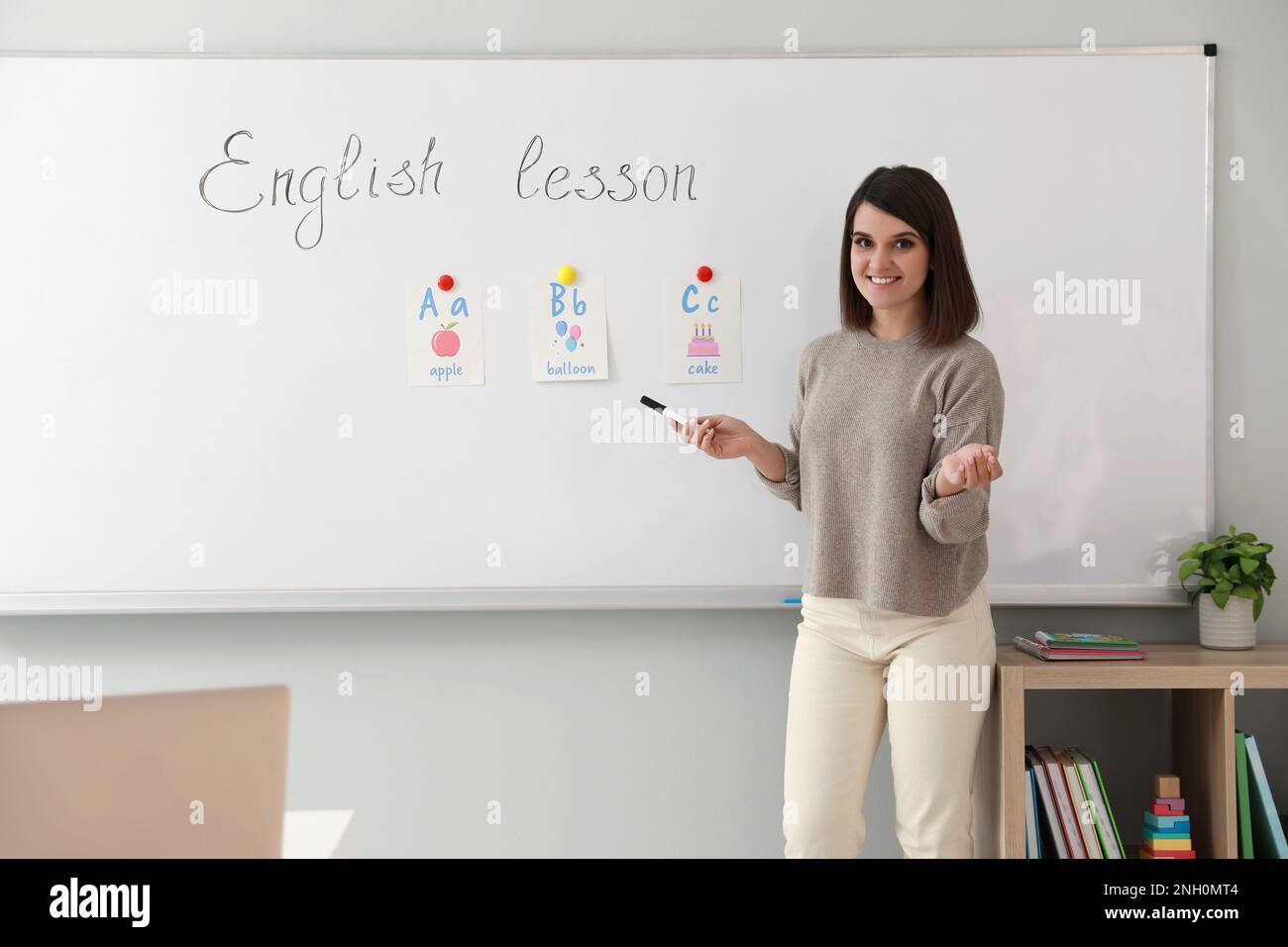 Happy female English teacher giving lesson indoors. Early childhood ...