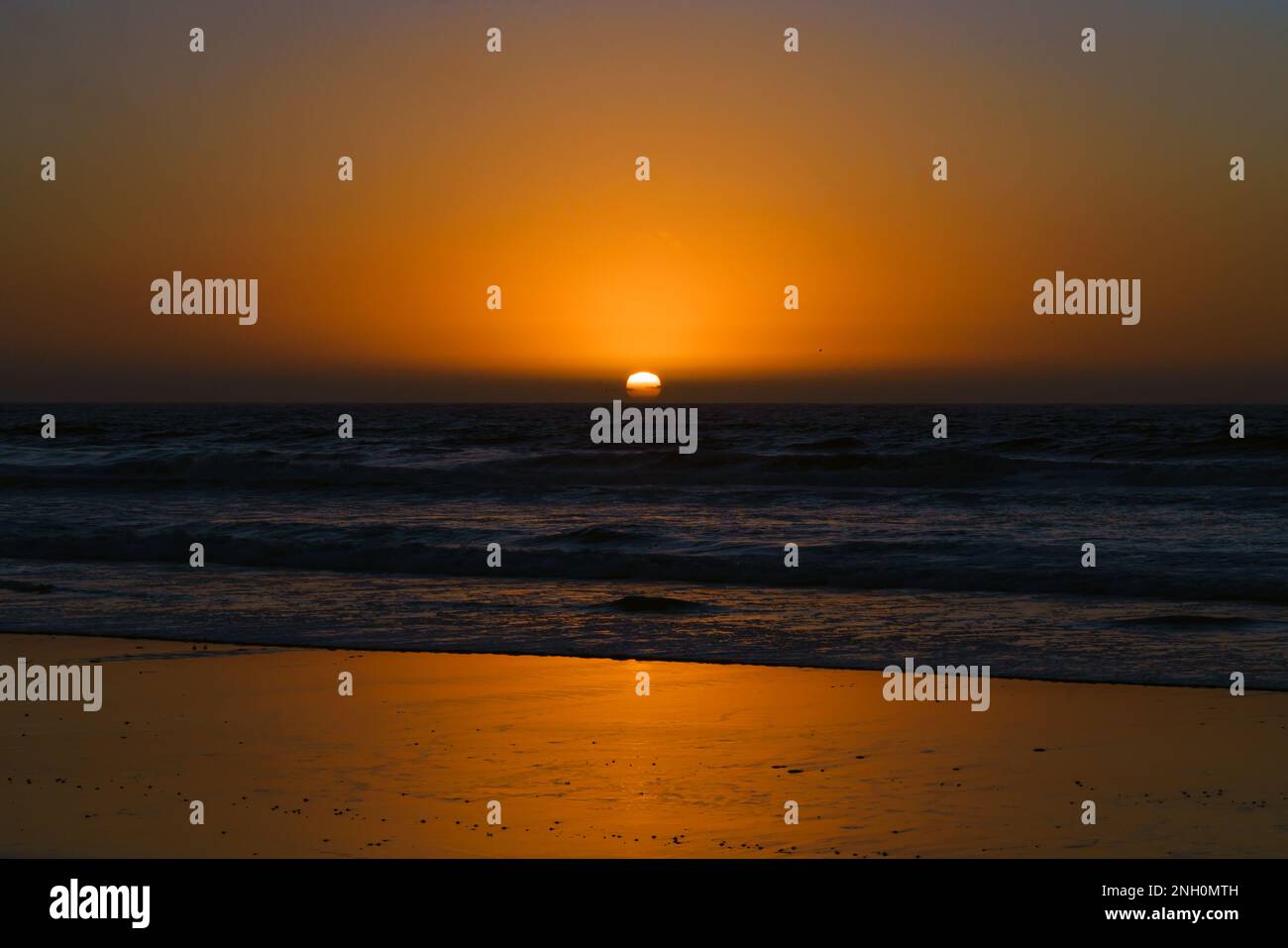 Golden sunset on the beach, tranquil scene. Sun setting down the ...
