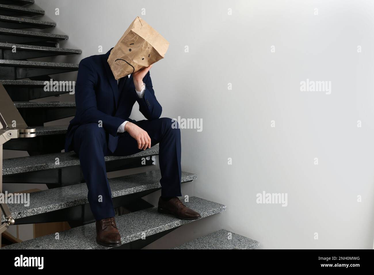 Man wearing paper bag with drawn sad face indoors. Space for text Stock ...