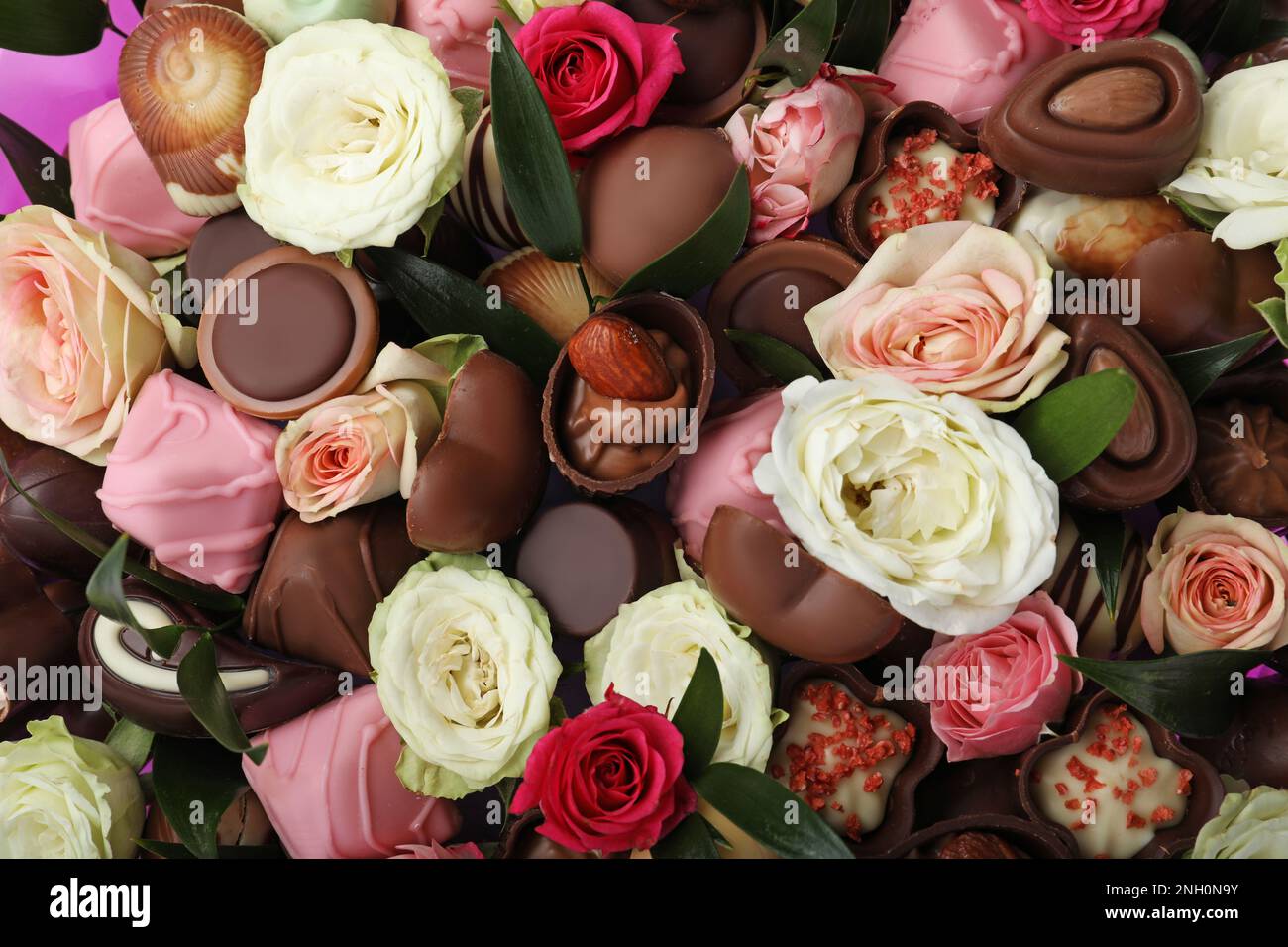 Beautiful bouquet of flowers and chocolate candies as background ...